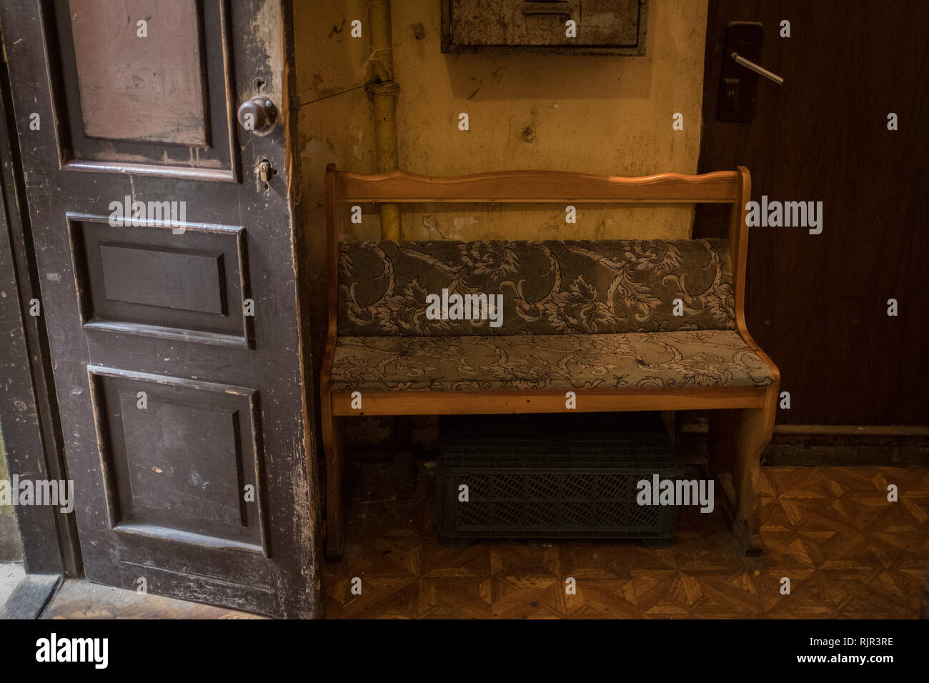 open wooden doorway with hallway into a tenement house with a bench ...