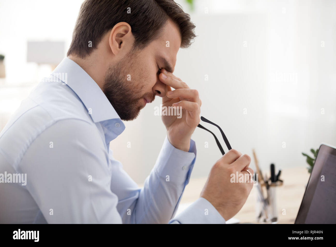 Tired businessman taking off glasses feeling pain eyestrain headache ...