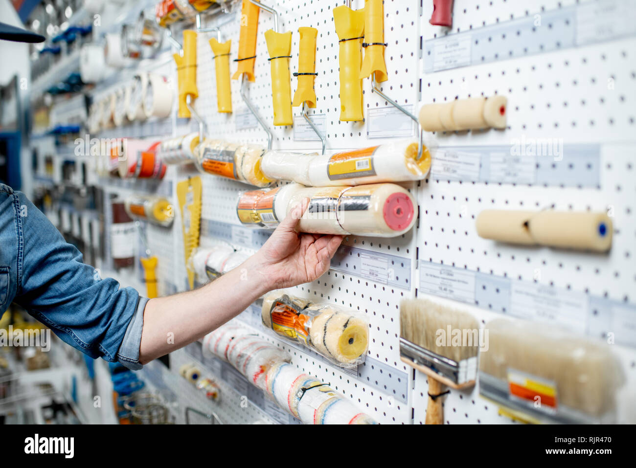 Workman choosing tools for painting in the building shop, close-up view ...