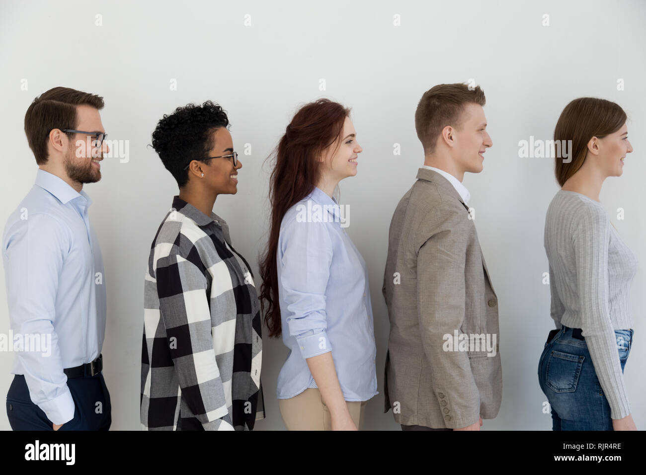 Side view at happy diverse business people standing in queue Stock ...