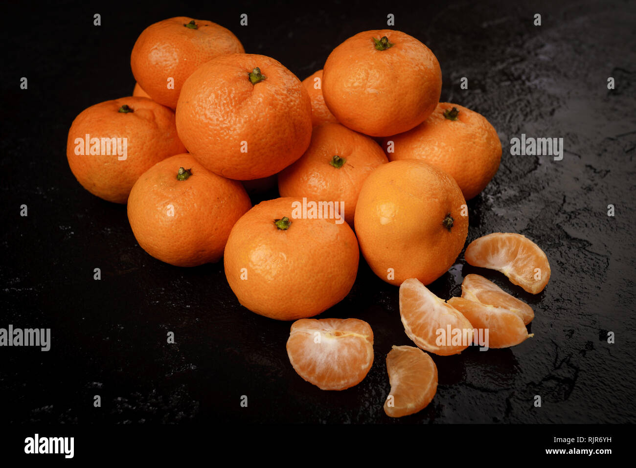 Group of mandarins on black background Stock Photo - Alamy