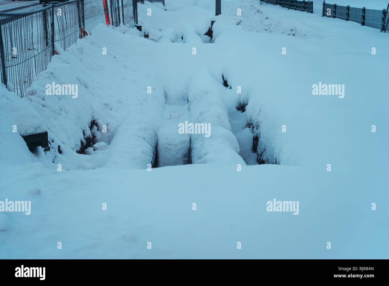 Two big pipes in the trench covered with some snow on a winter day at a ...