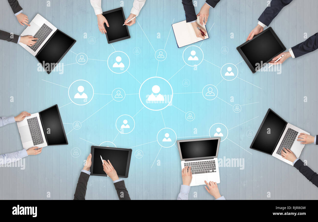 Group of people with devices in hands working in team on tablets ...