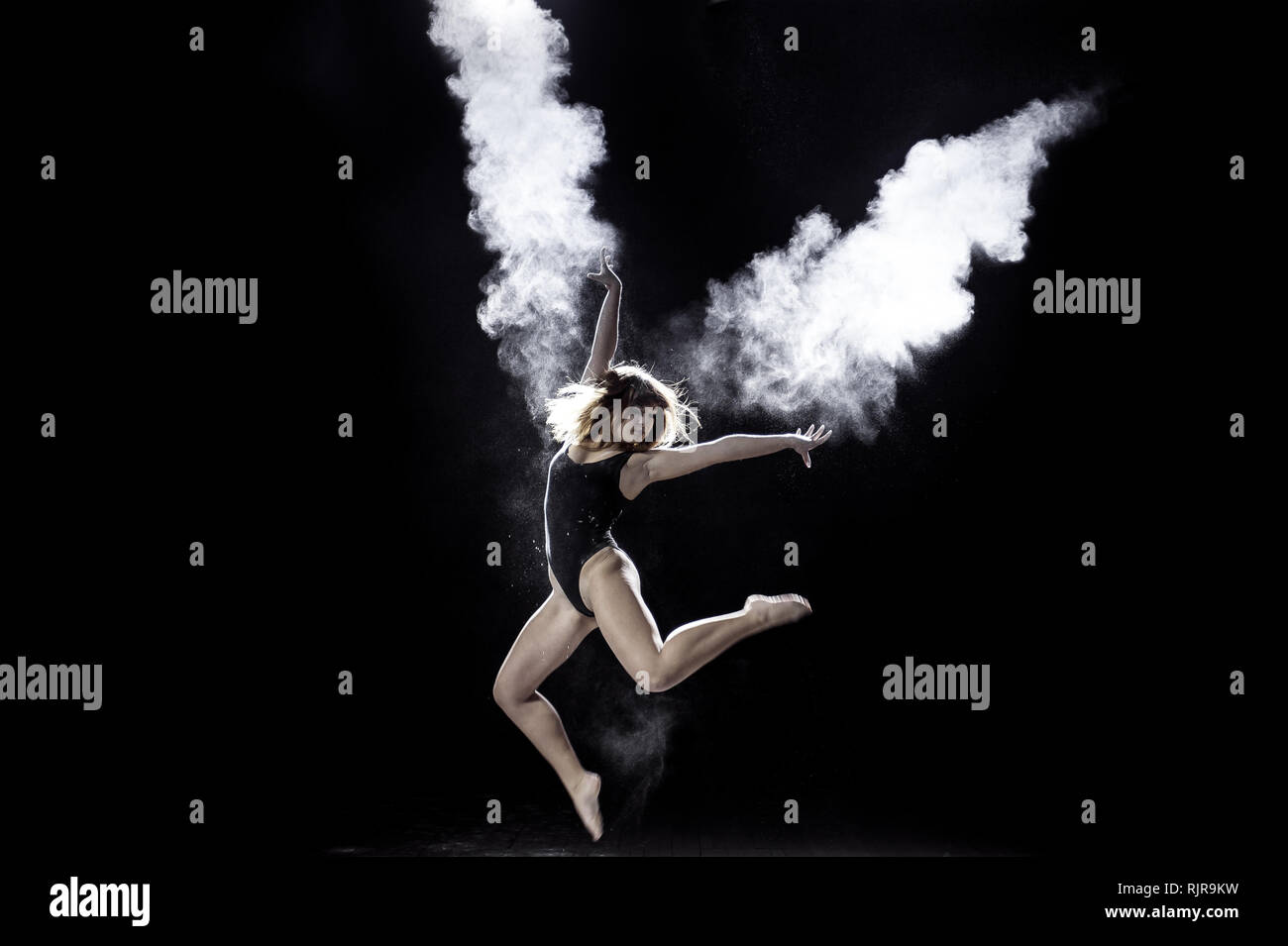 Girl dancing with a flour on the black background on the sceene Stock ...