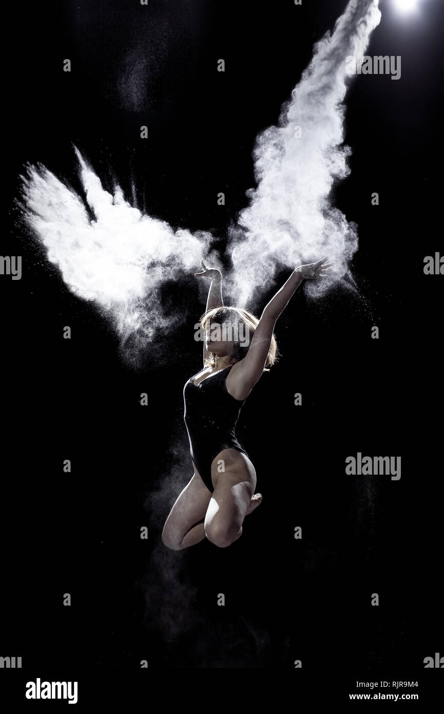 Girl dancing with a flour on the black background on the sceene Stock ...