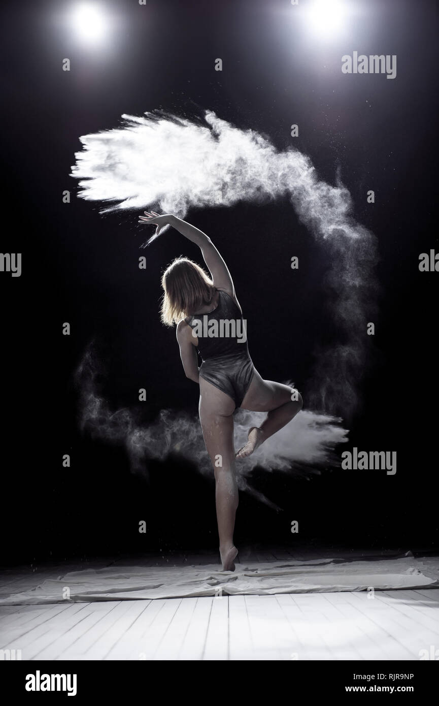 Girl dancing with a flour on the black background on the sceene Stock ...