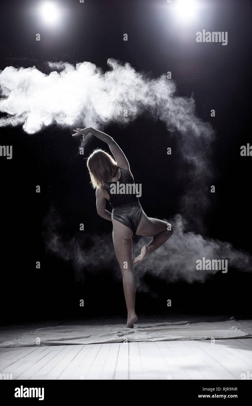 Girl dancing with a flour on the black background on the sceene Stock ...