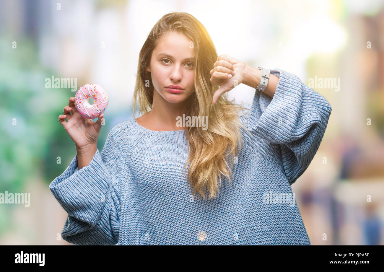 Young beautiful blonde woman eating sweet donut over isolated ...