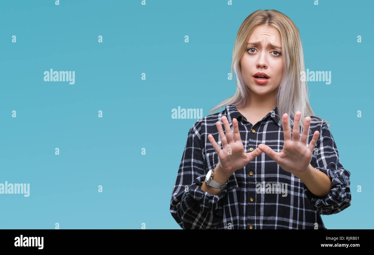 Young blonde woman over isolated background afraid and terrified with ...