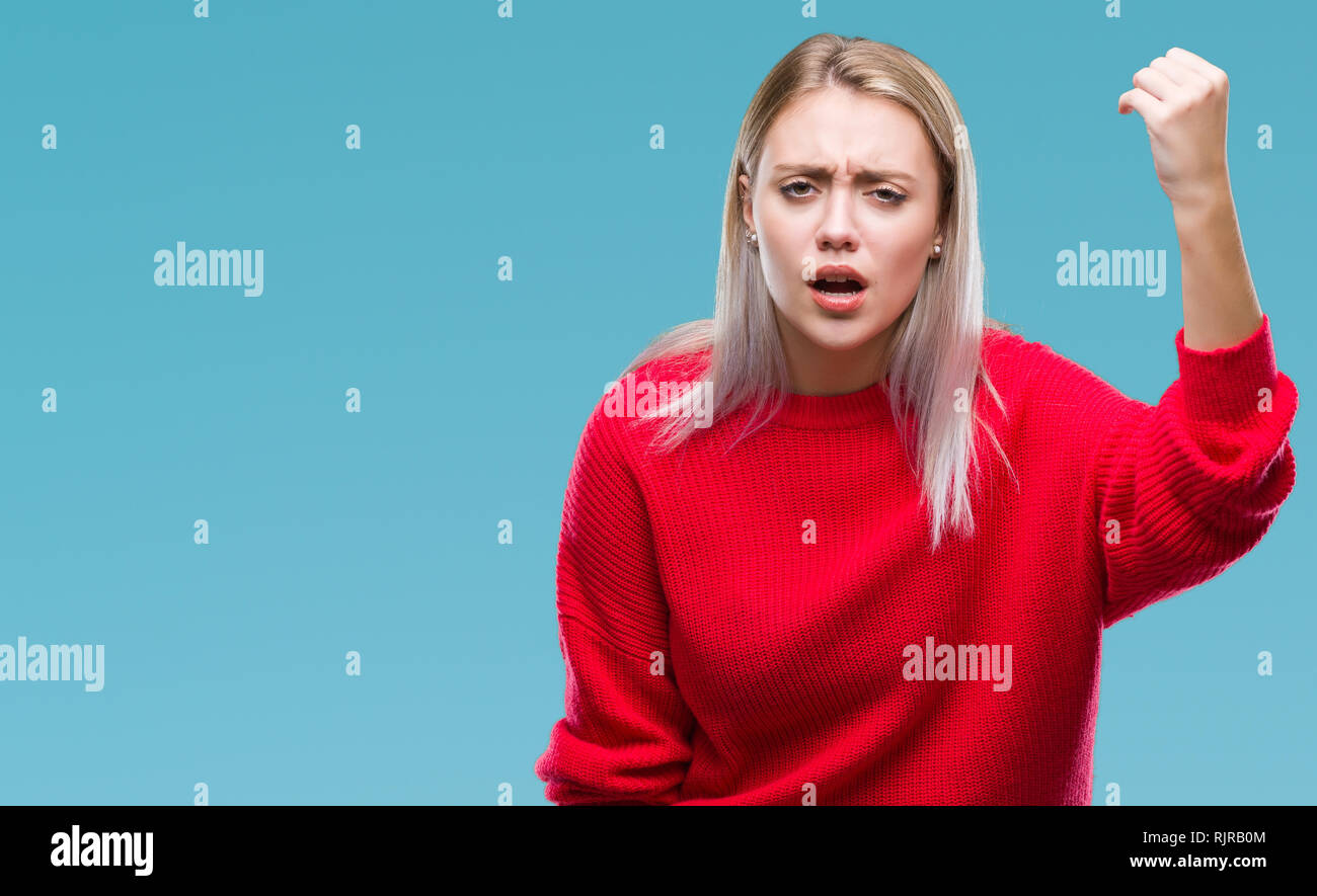 Young blonde woman wearing winter sweater over isolated background ...