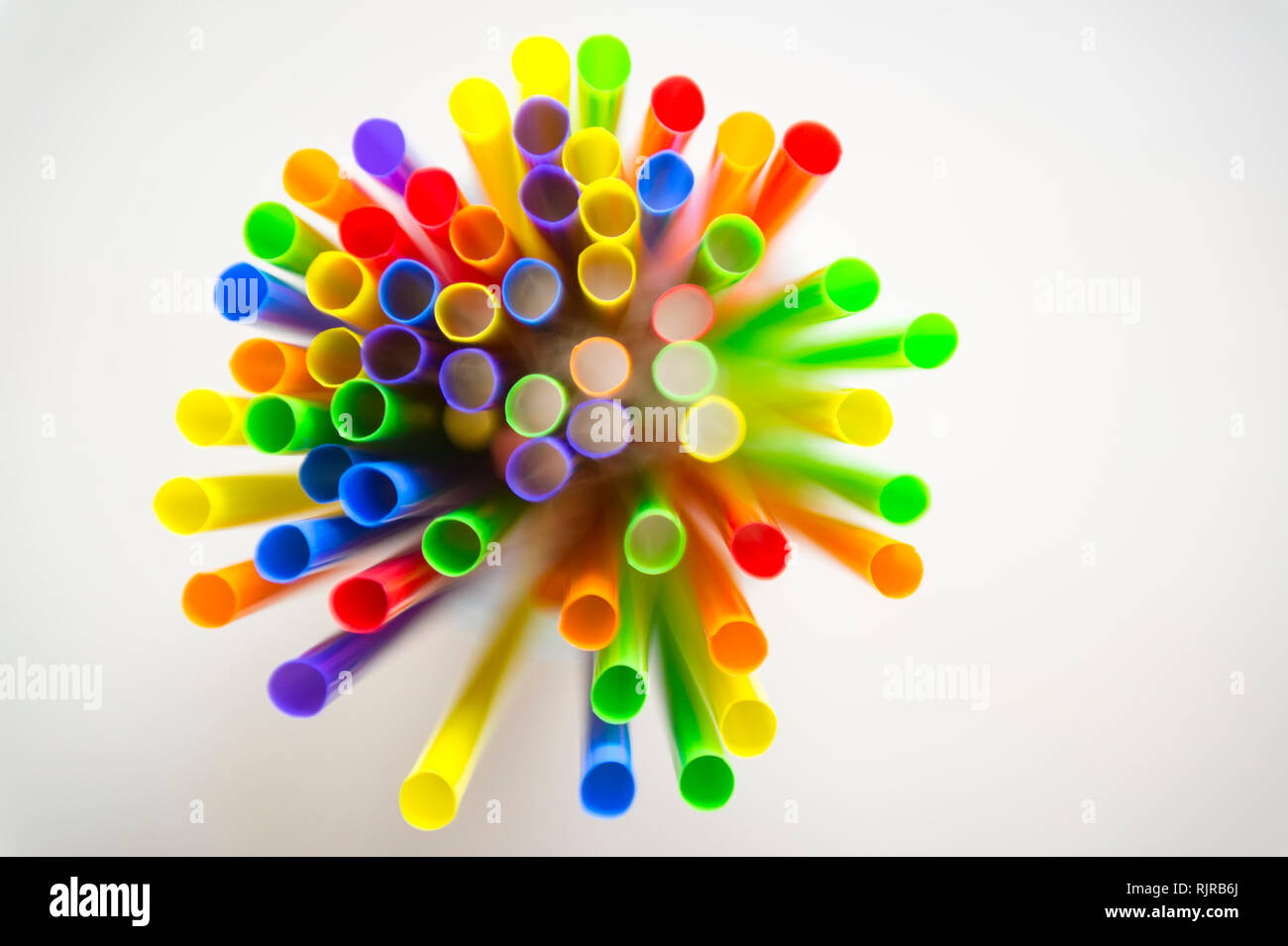 Abstract view from above of brightly colored plastic straws sticking up ...