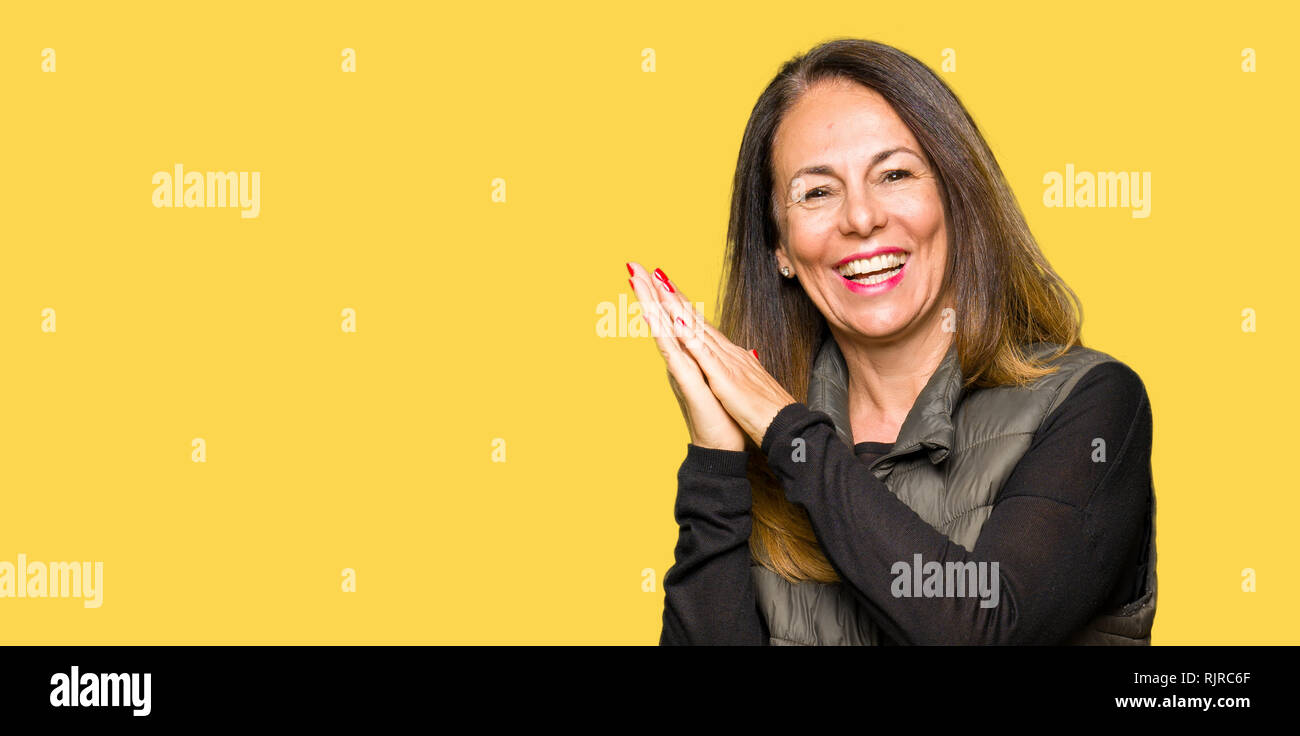 Beautiful middle age woman wearing winter vest Clapping and applauding ...