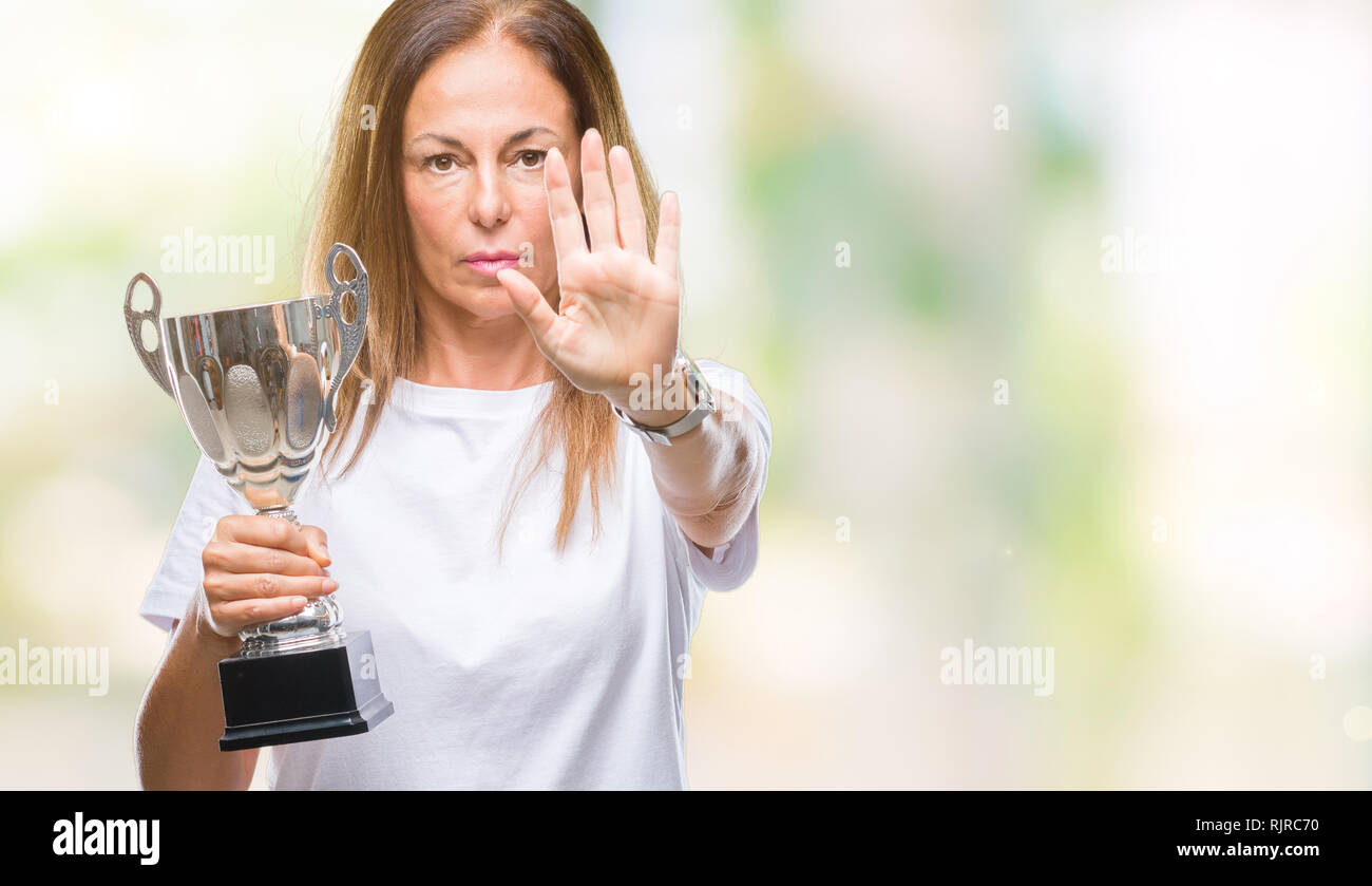 Middle age hispanic winner woman celebrating award holding trophy over ...