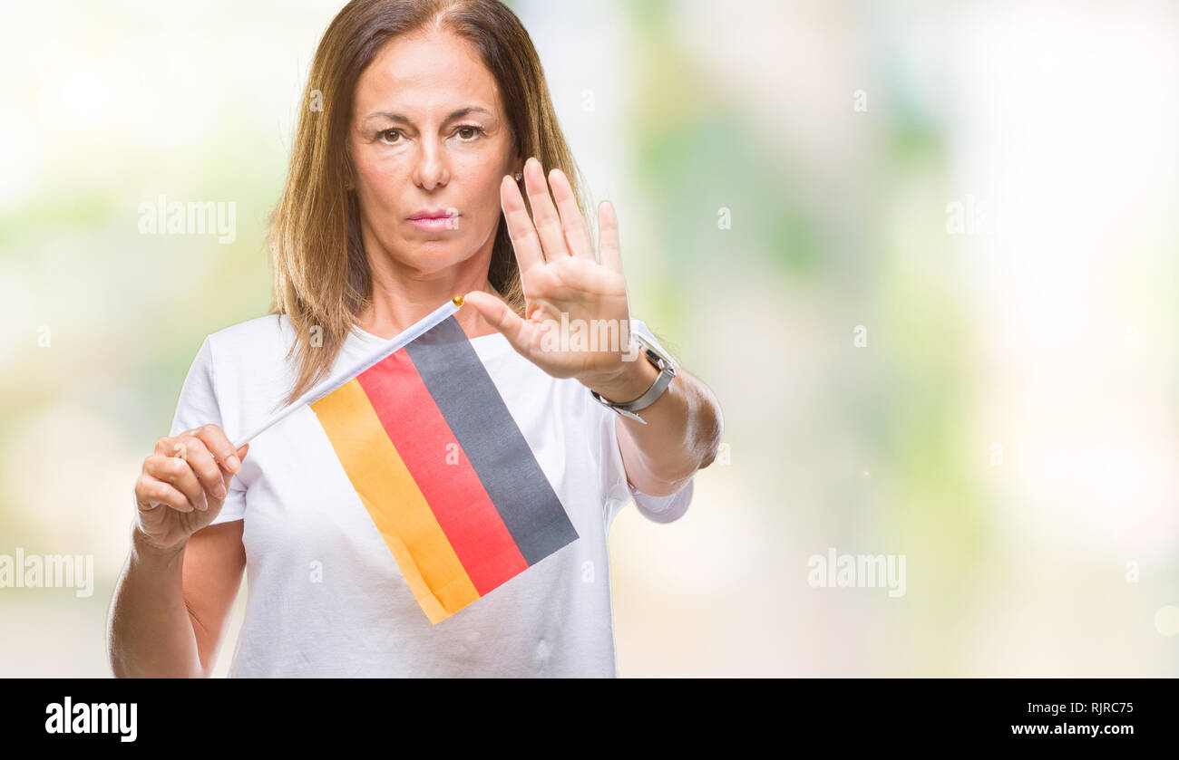 Middle age hispanic woman holding flag of Germany over isolated ...