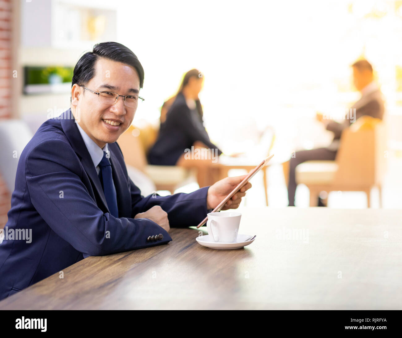 Portrait of Businessman working in cafe with smart phone and tablet ...
