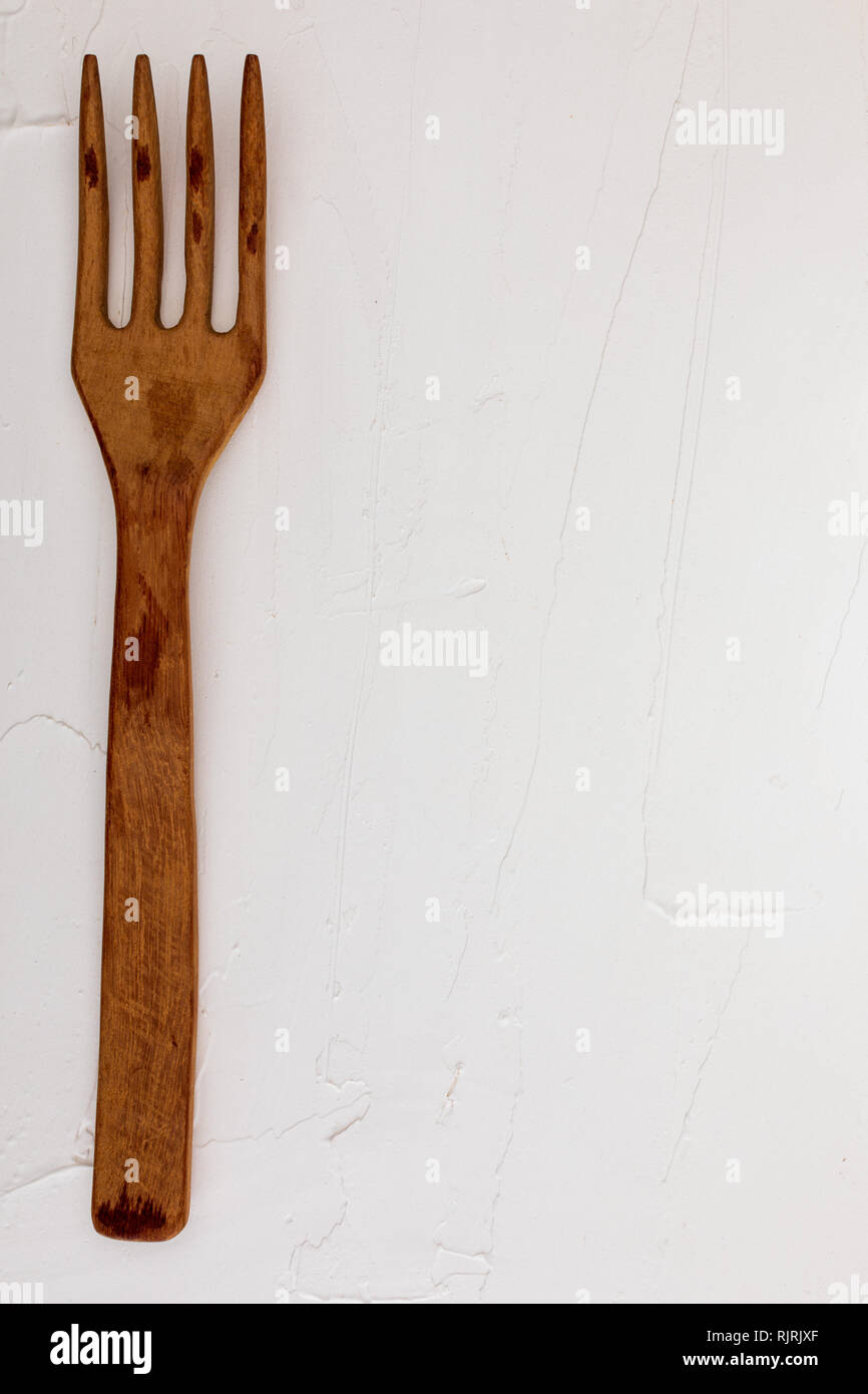 Wooden fork on white background with texture. Space to insert your text ...