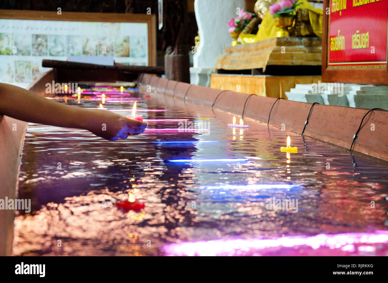 Ritual praying colorful candle floating on water for pray reclining ...