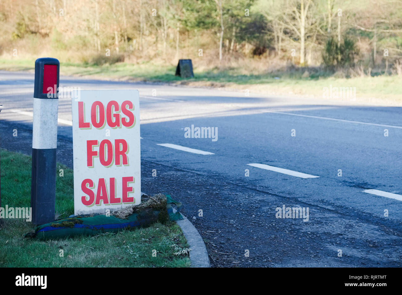 Logs wood for sale sign at farm shop for biomass burner Stock Photo - Alamy