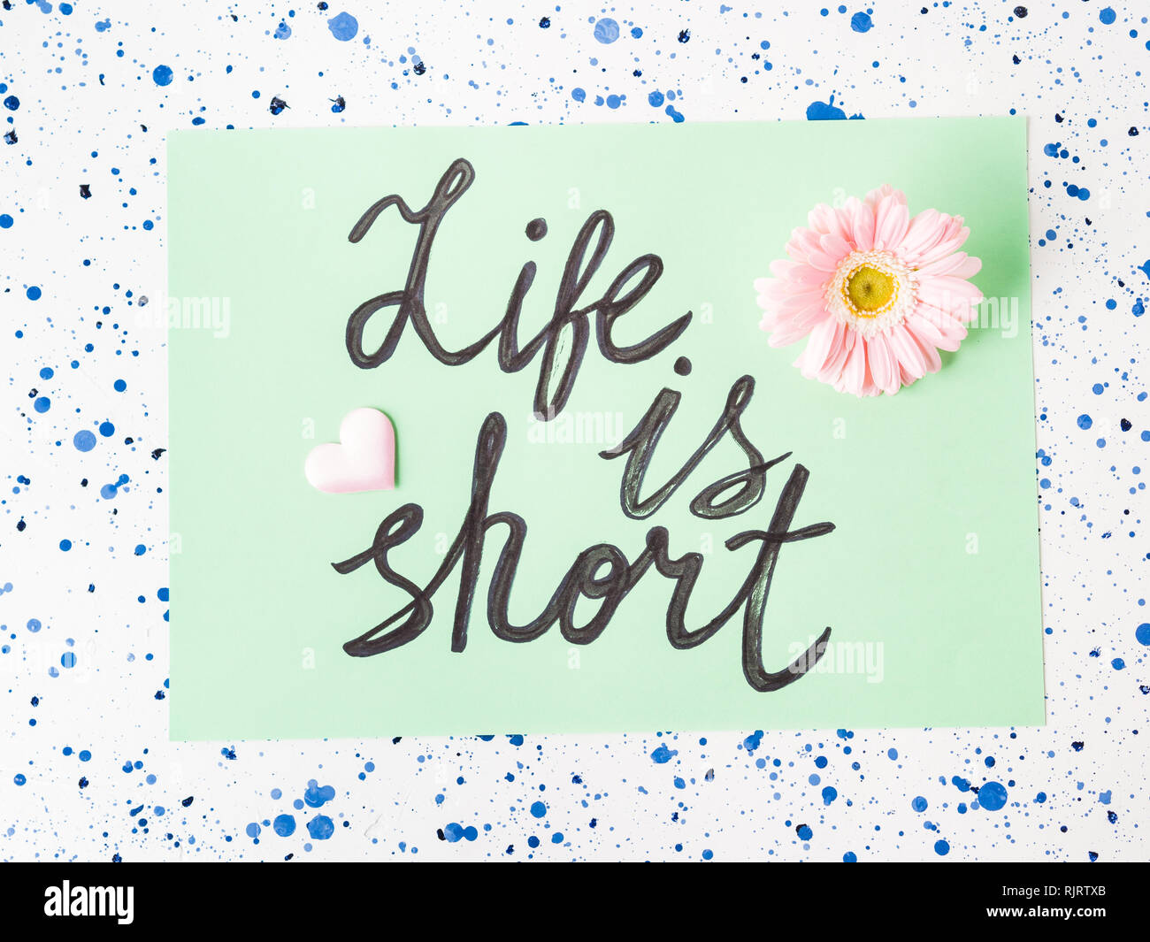 Life is short quote written on green sheet on pastel green background ...