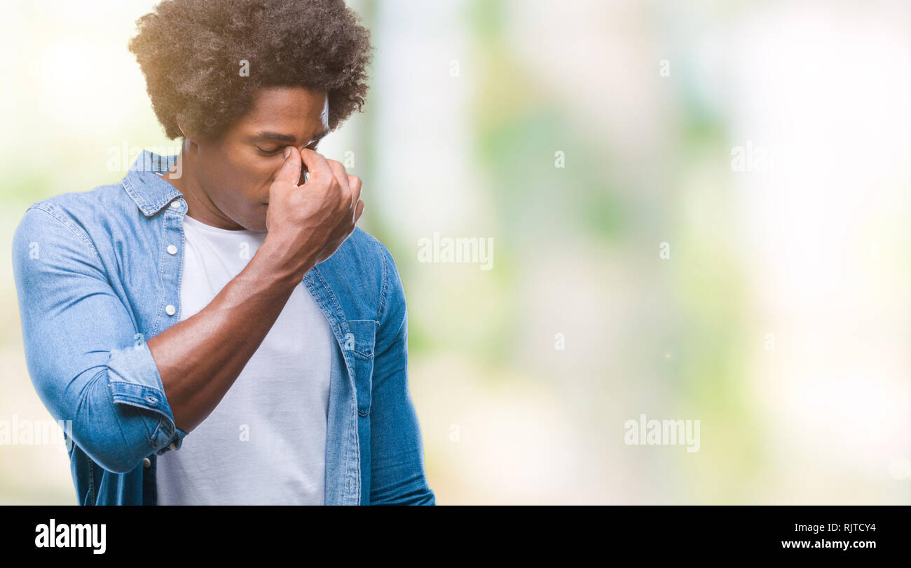 Afro american man over isolated background tired rubbing nose and eyes ...