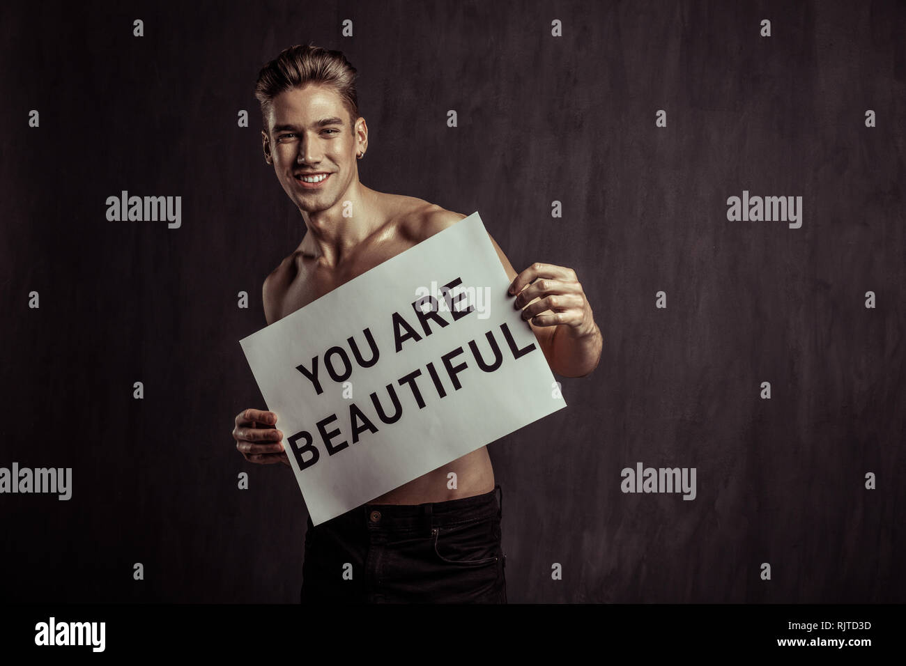 Joyful positive man standing against dark background Stock Photo - Alamy