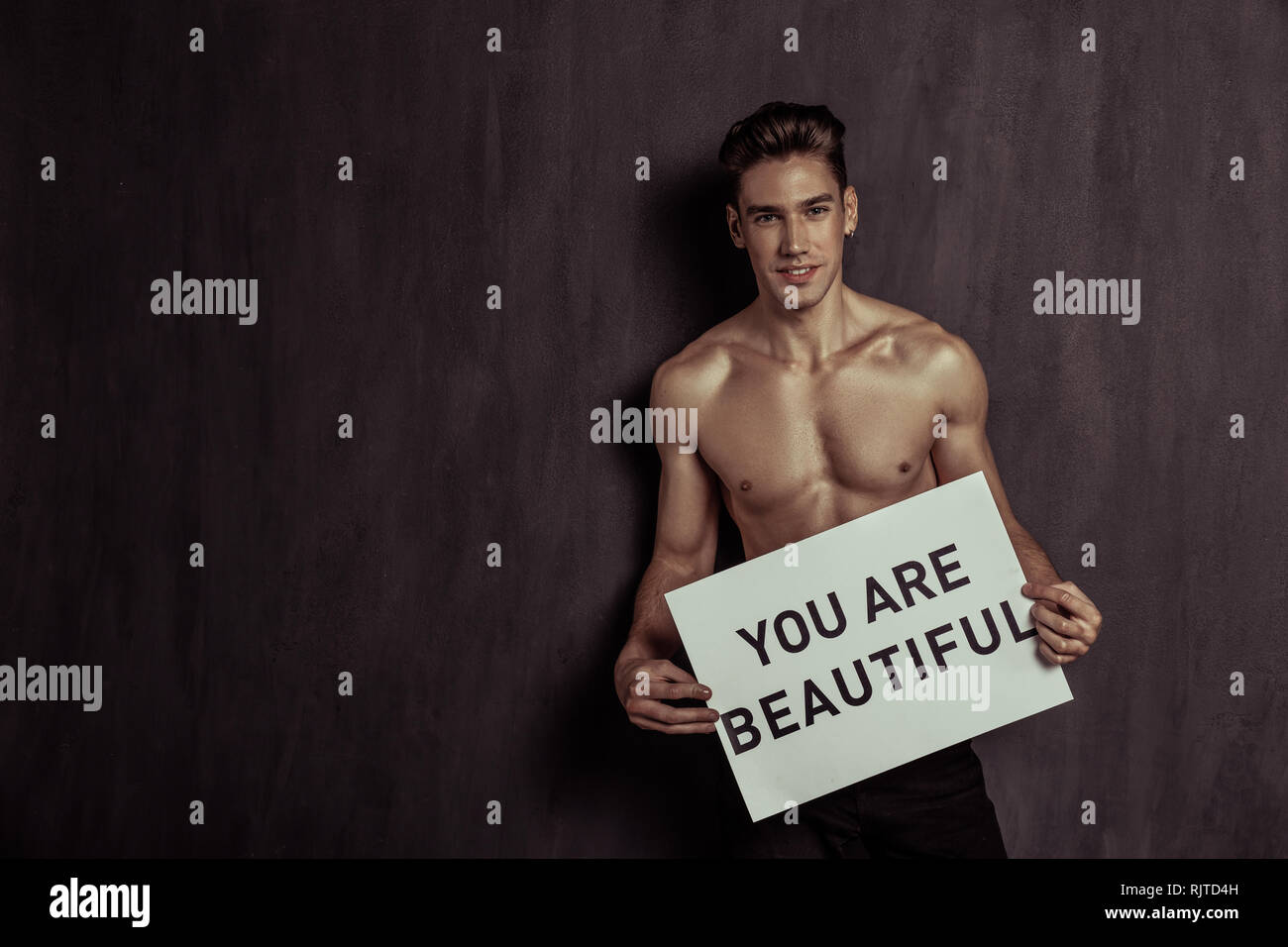 Joyful good looking man showing you a sign Stock Photo - Alamy
