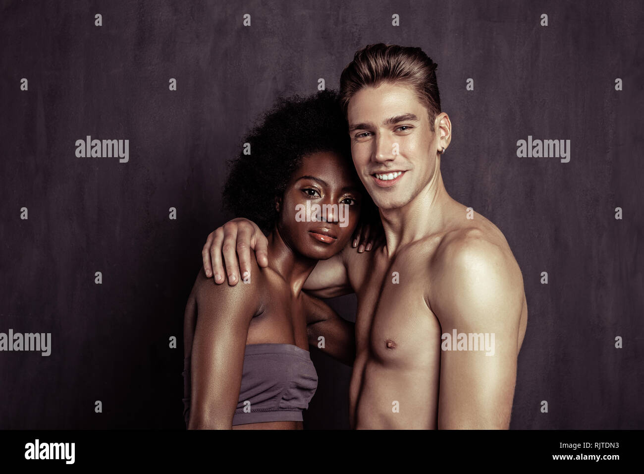 Delighted nice young couple smiling to you Stock Photo - Alamy