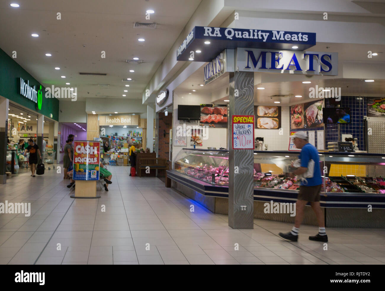Interior of modern shopping centre with people strolling through mall ...