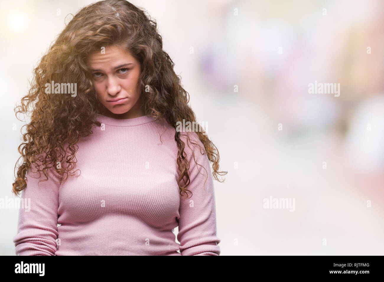 Beautiful brunette curly hair young girl wearing pink sweater over ...