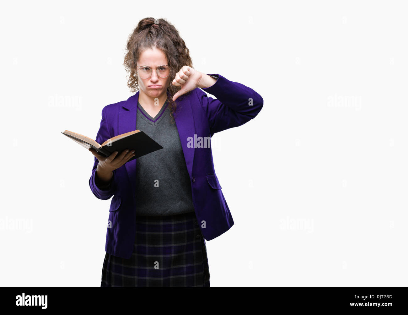 Young brunette student girl wearing school uniform reading a book over ...