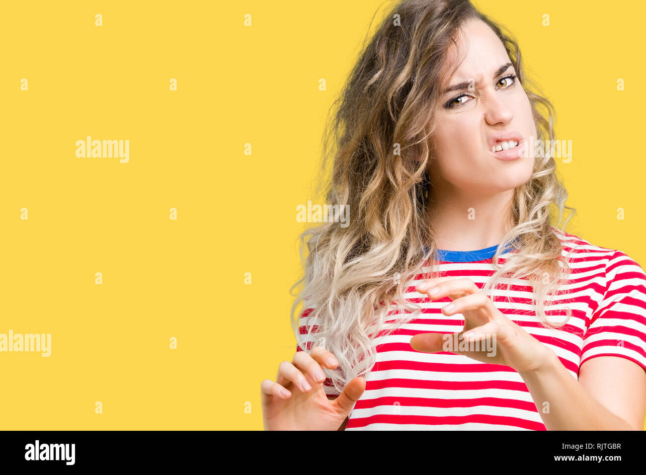 Beautiful young blonde woman over isolated background disgusted ...