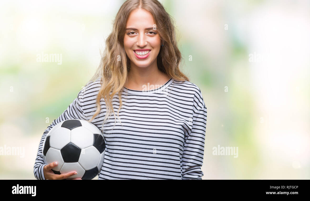 Beautiful young blonde woman holding soccer football ball over isolated ...
