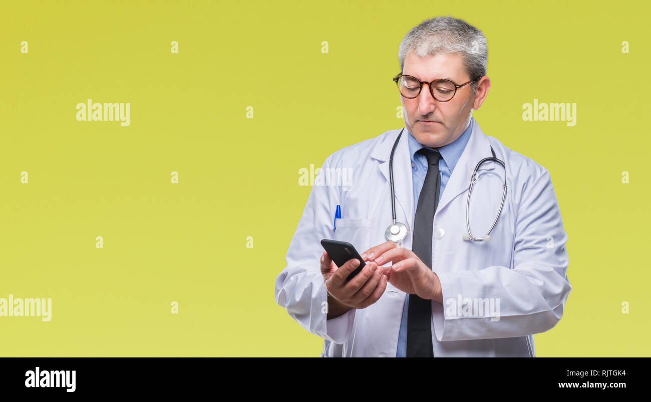 Handsome senior doctor man texting sending message using smarpthone ...
