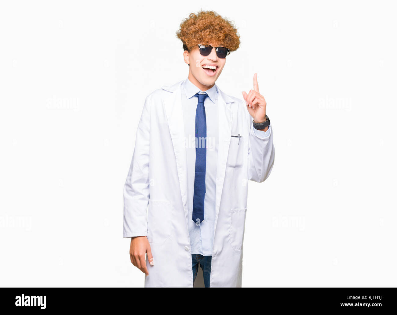 Young handsome scientist man wearing professional coat and sunglasses ...