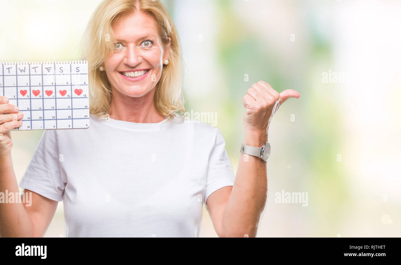 Middle age blonde woman holding menstruation calendar ver isolated ...