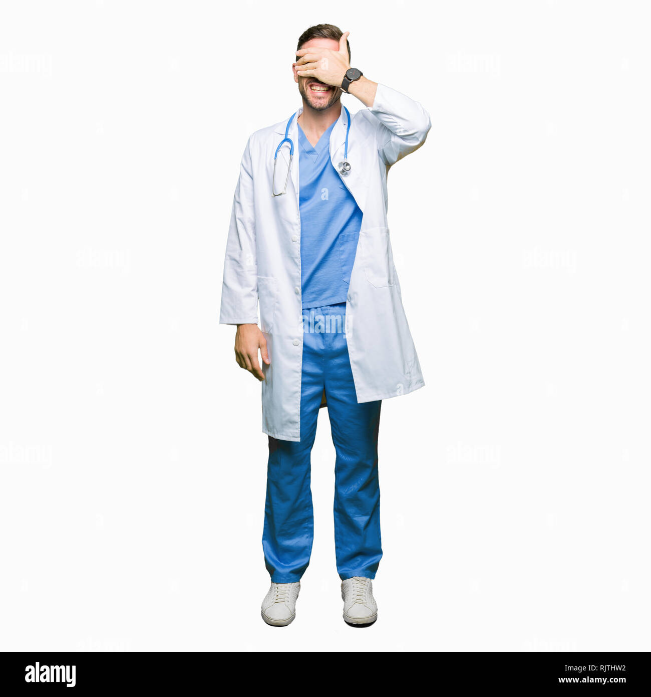 Handsome doctor man wearing medical uniform over isolated background ...
