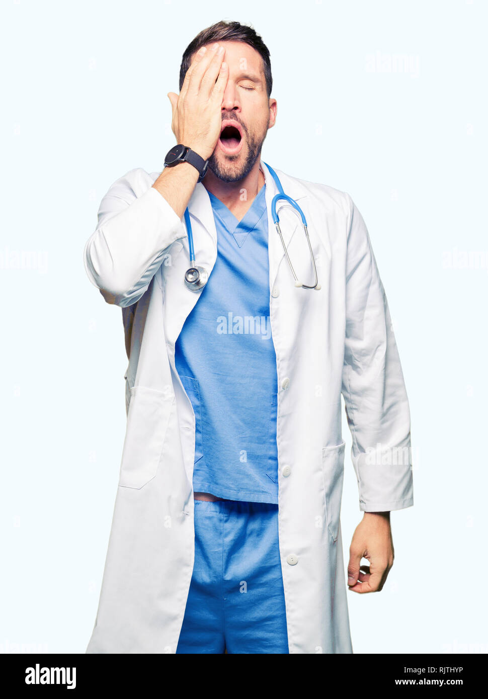 Handsome doctor man wearing medical uniform over isolated background ...