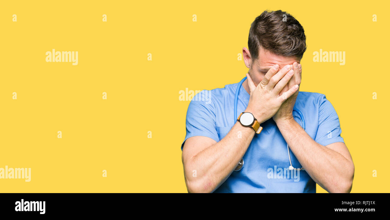 Handsome doctor man wearing medical uniform over isolated background ...