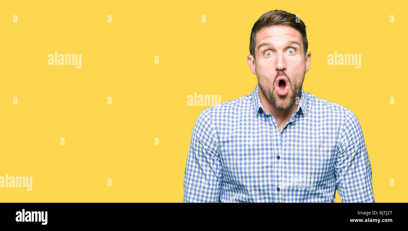 Handsome business man with blue eyes afraid and shocked with surprise ...