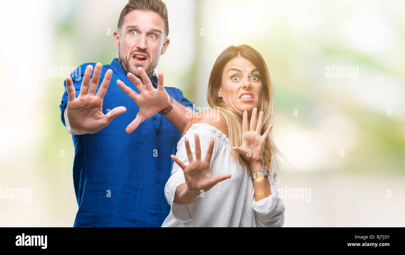 Young couple in love over isolated background afraid and terrified with ...