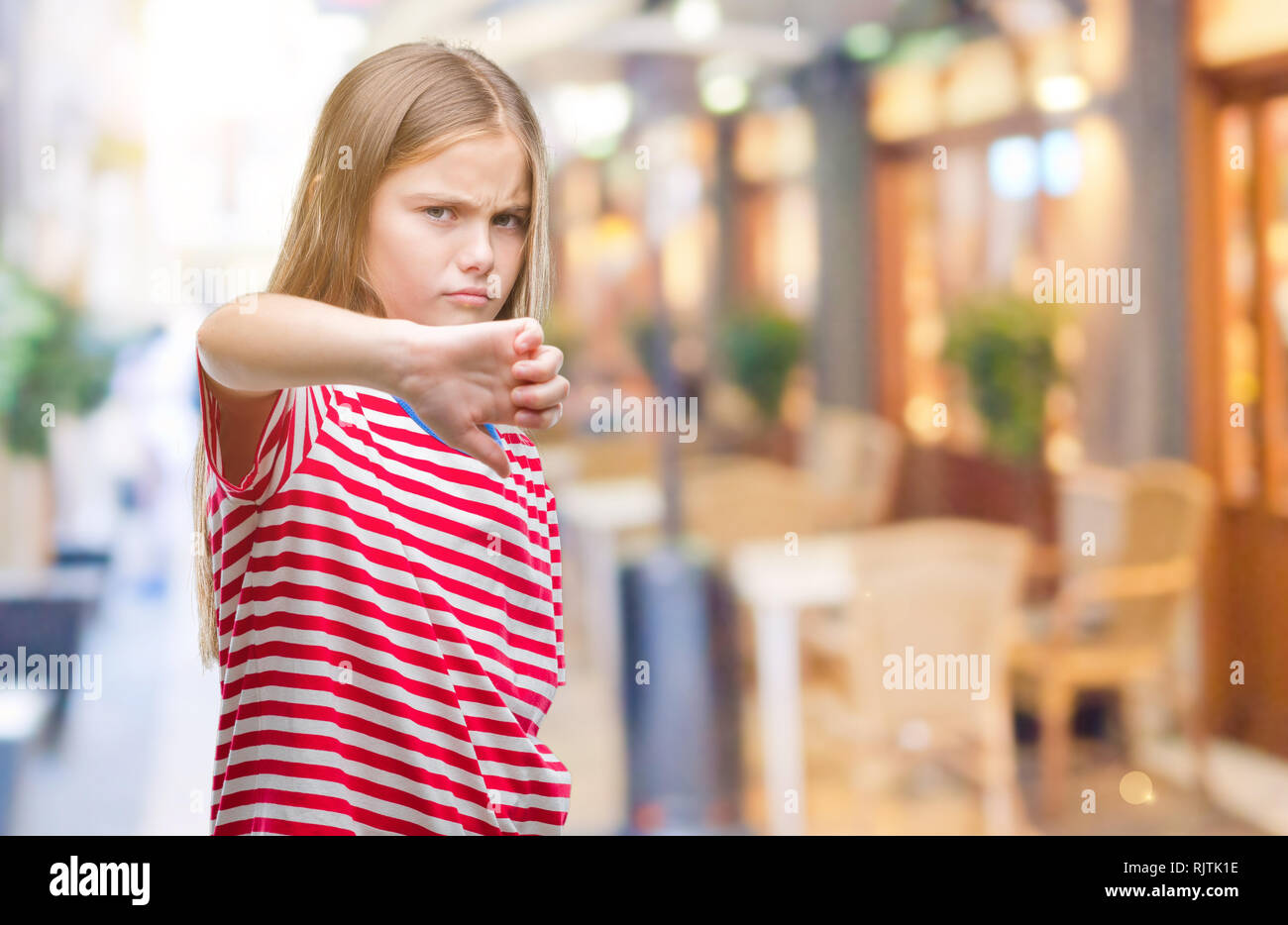 Young beautiful girl over isolated background looking unhappy and angry ...