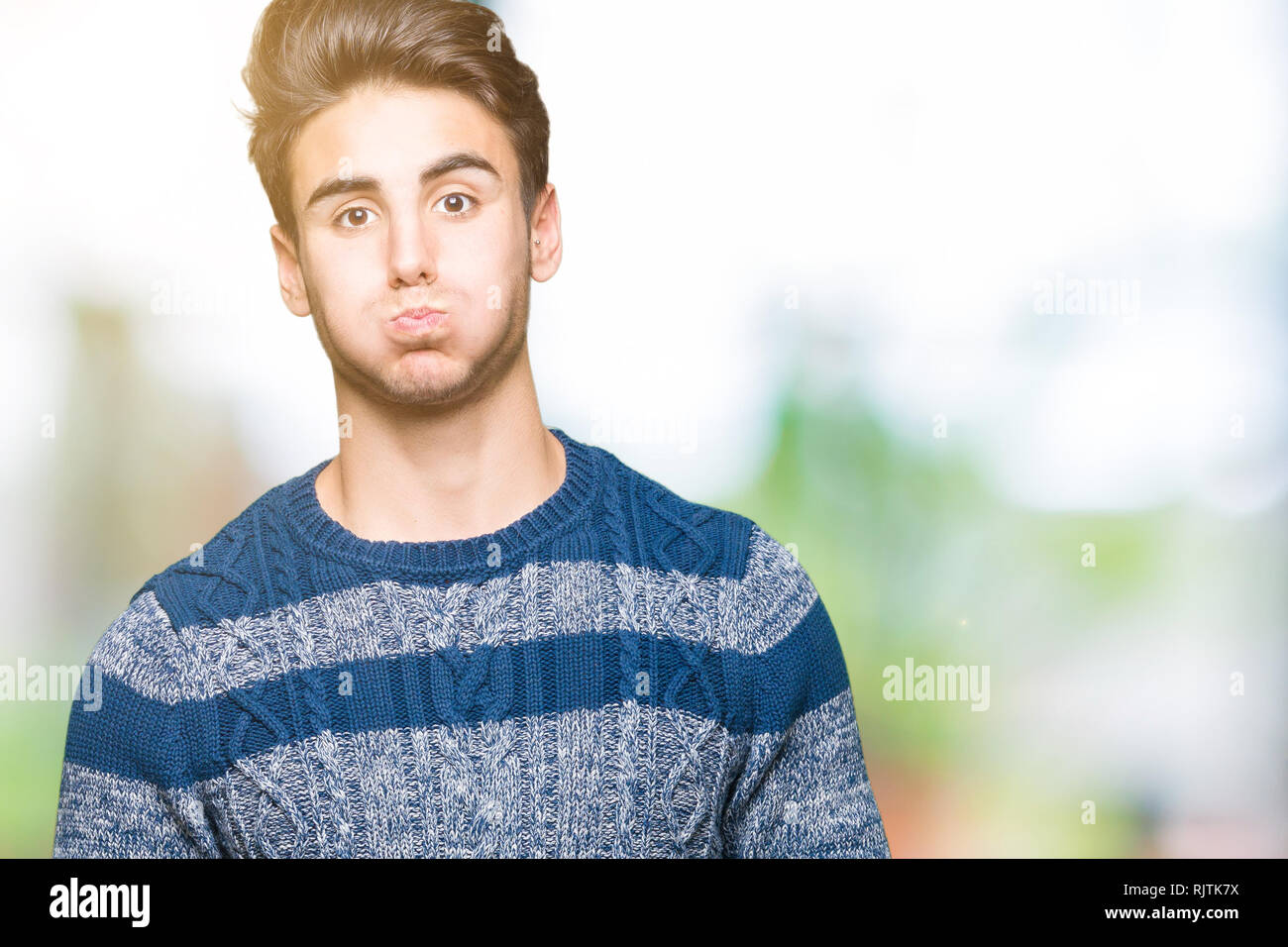 Young handsome man over isolated background puffing cheeks with funny ...