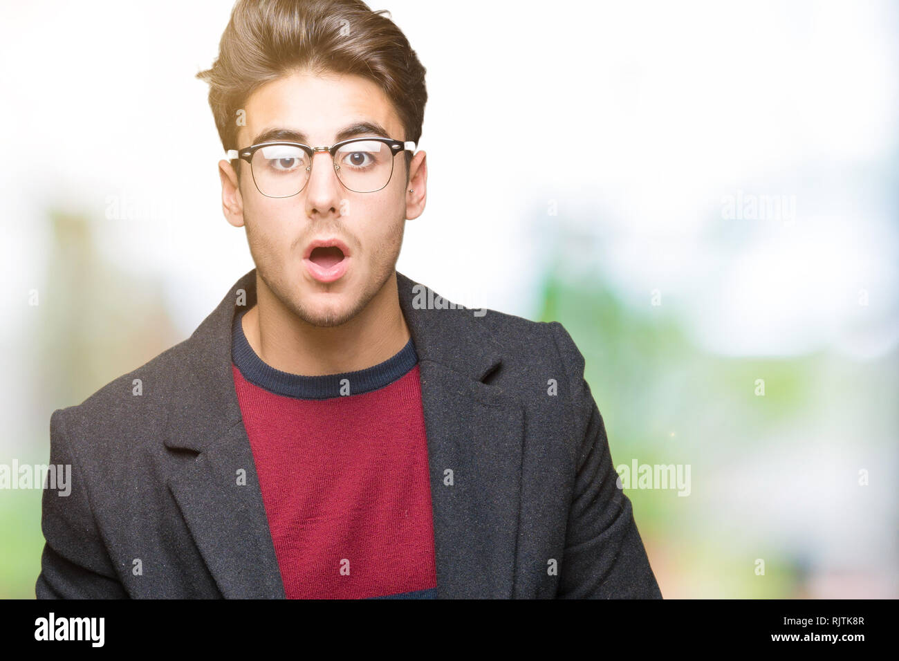 Young handsome elegant man wearing glasses over isolated background afraid and shocked with ...