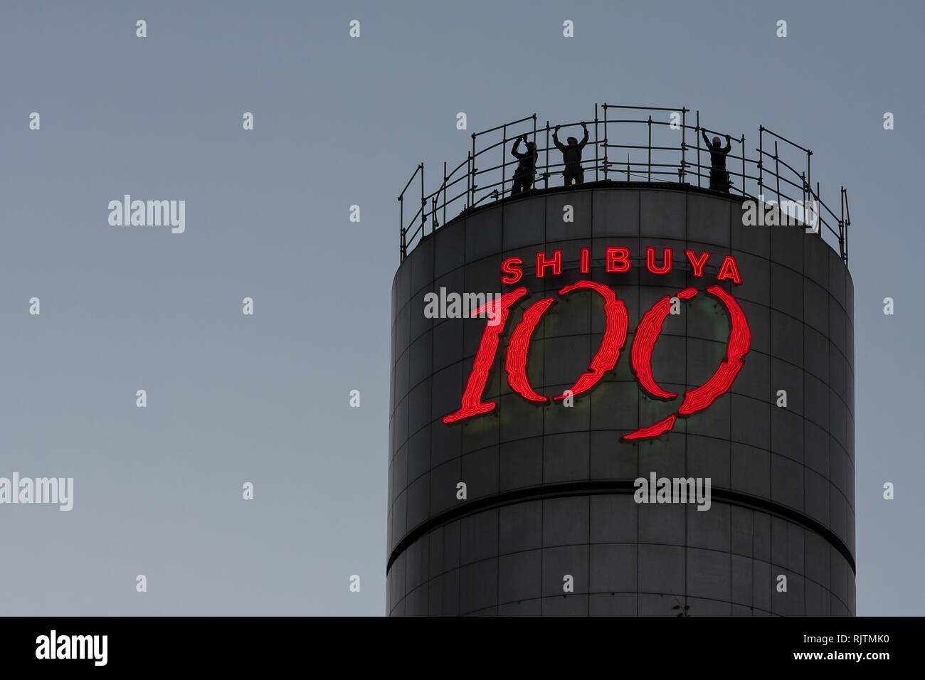 Workmen in silhouette on top of the iconic Shibuya 109 tower in Shibuya ...