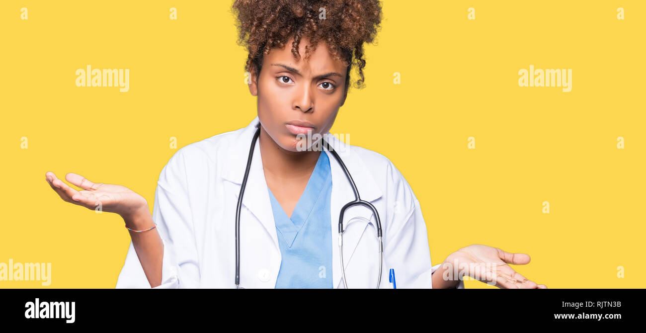 Young african american doctor woman over isolated background clueless ...