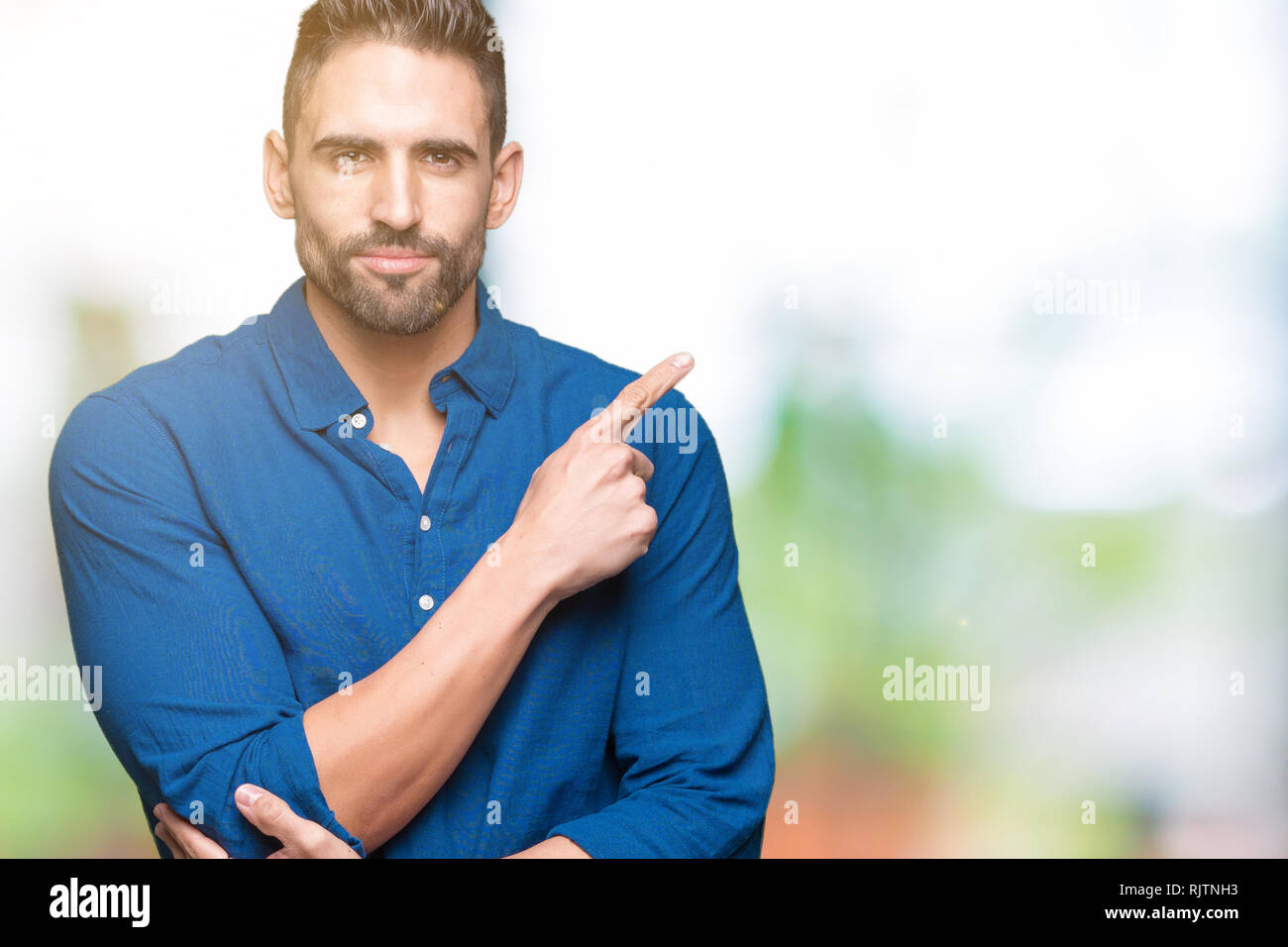 Young handsome man over isolated background Pointing with hand finger ...