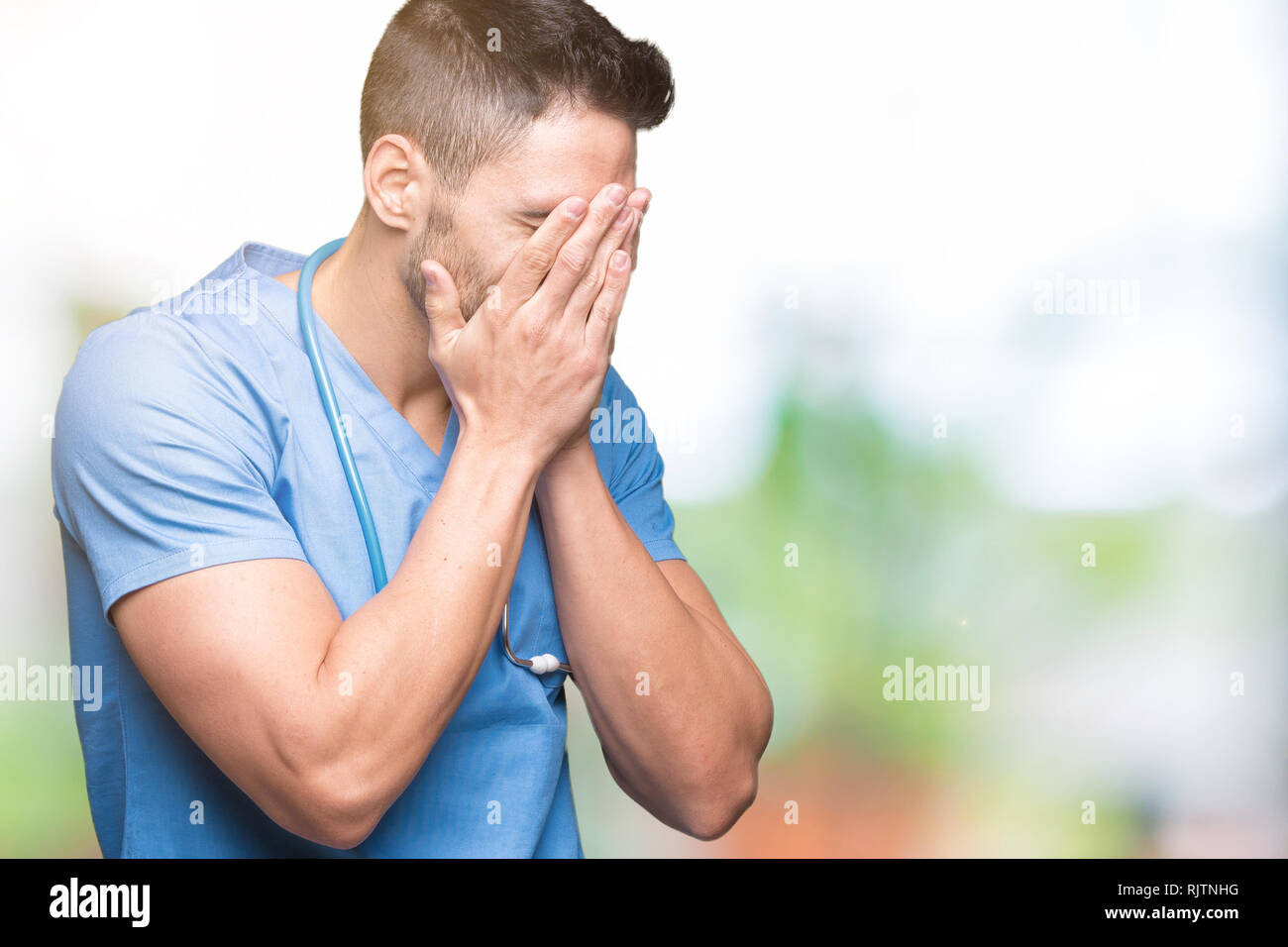 Handsome young doctor surgeon man over isolated background with sad ...
