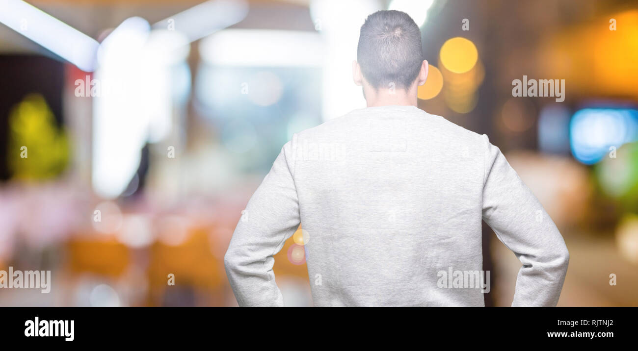 Young handsome man wearing sweatshirt over isolated background standing ...