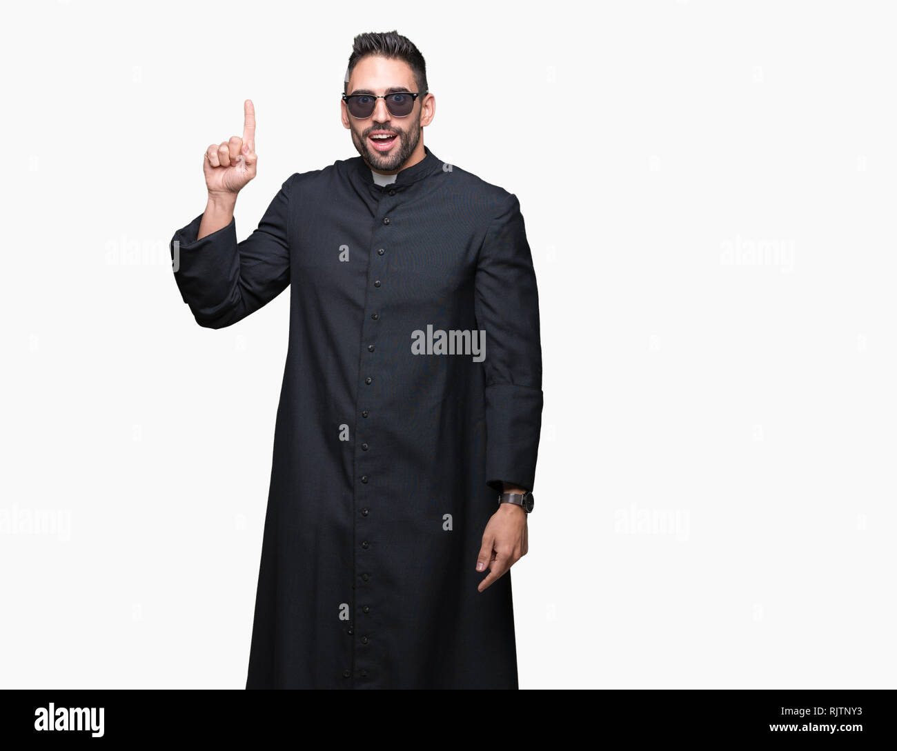 Young Christian priest wearing sunglasses over isolated background ...