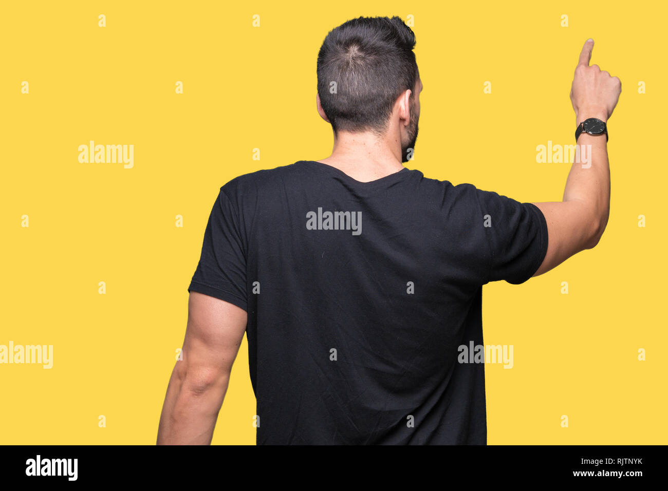 Young handsome man over isolated background Posing backwards pointing ...